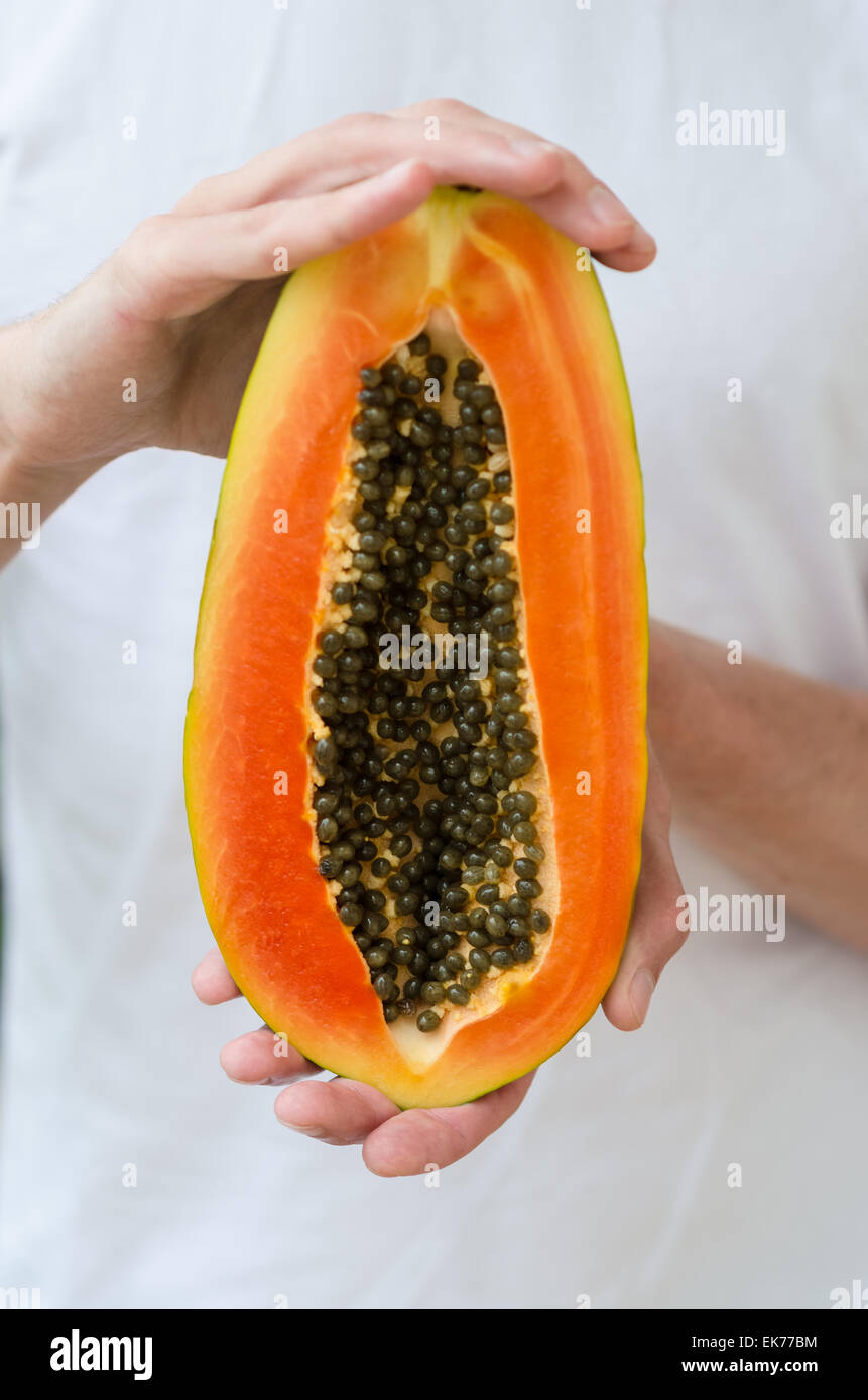 Hands holding a papaya slice Stock Photo - Alamy