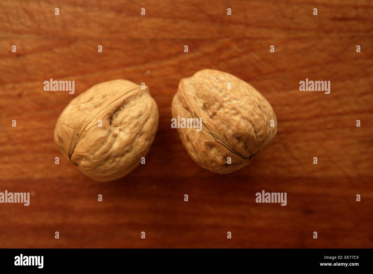 Two walnuts on a golden wood table Stock Photo - Alamy
