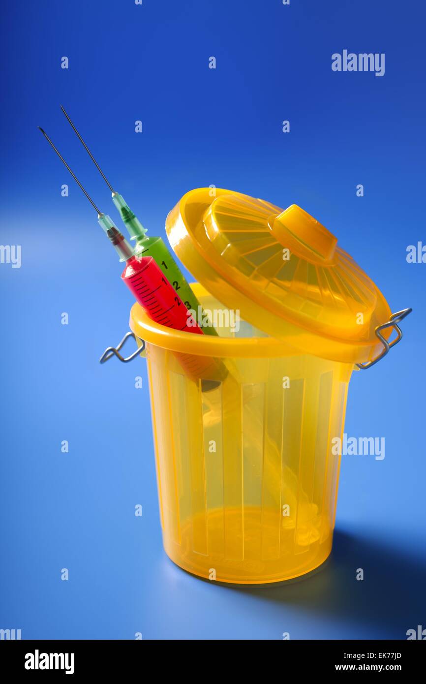 Two red and green syringe on the trash Stock Photo - Alamy