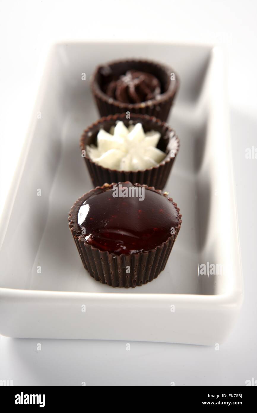 Three little chocolate cakes in a line Stock Photo - Alamy