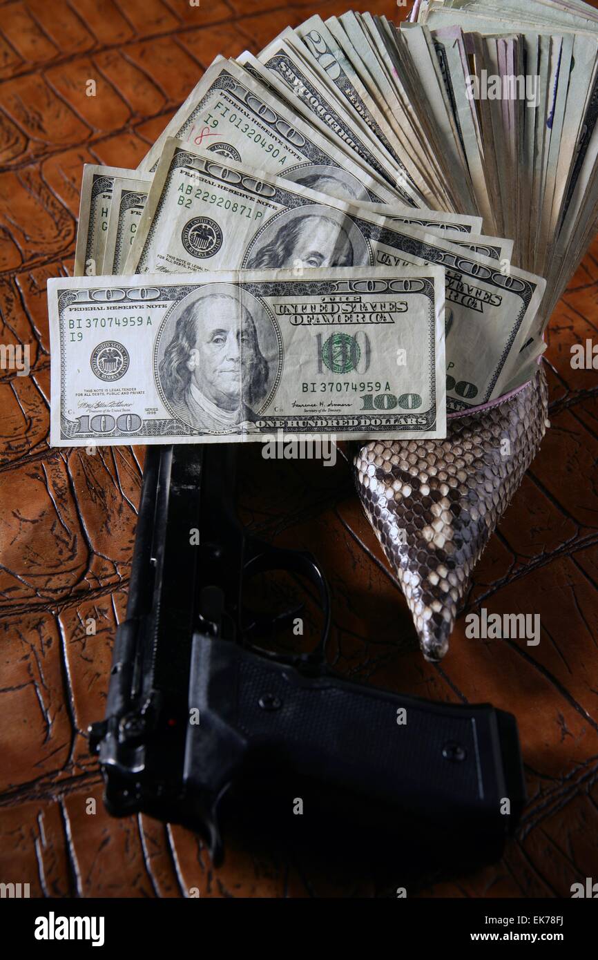 Dollar notes and gun, black pistol Stock Photo - Alamy