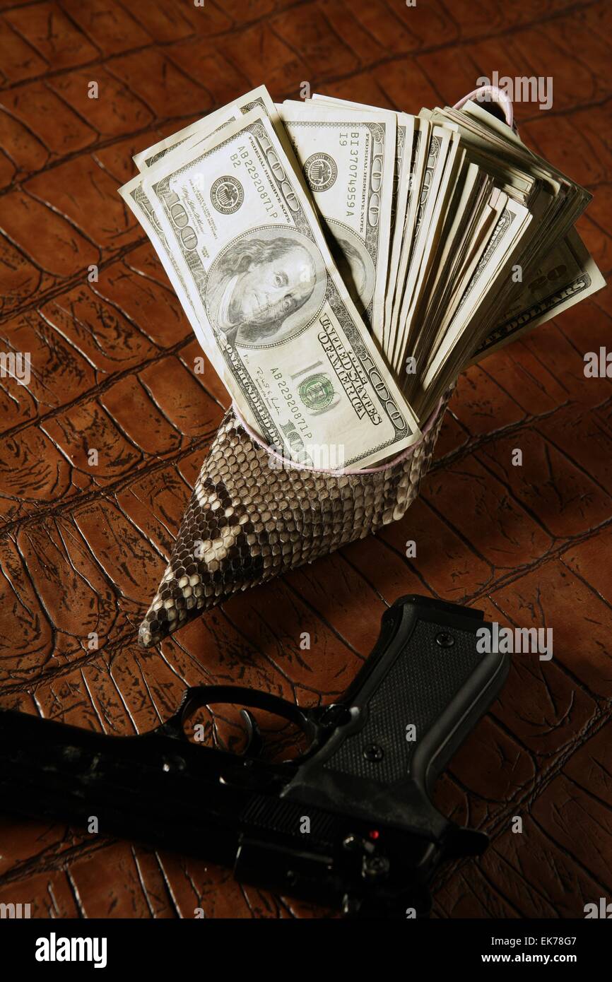Dollar notes and gun, black pistol Stock Photo - Alamy