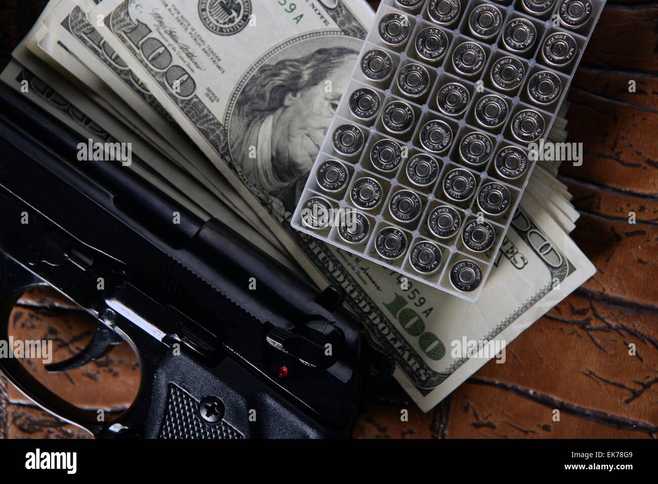 Dollar notes and gun, black pistol Stock Photo - Alamy