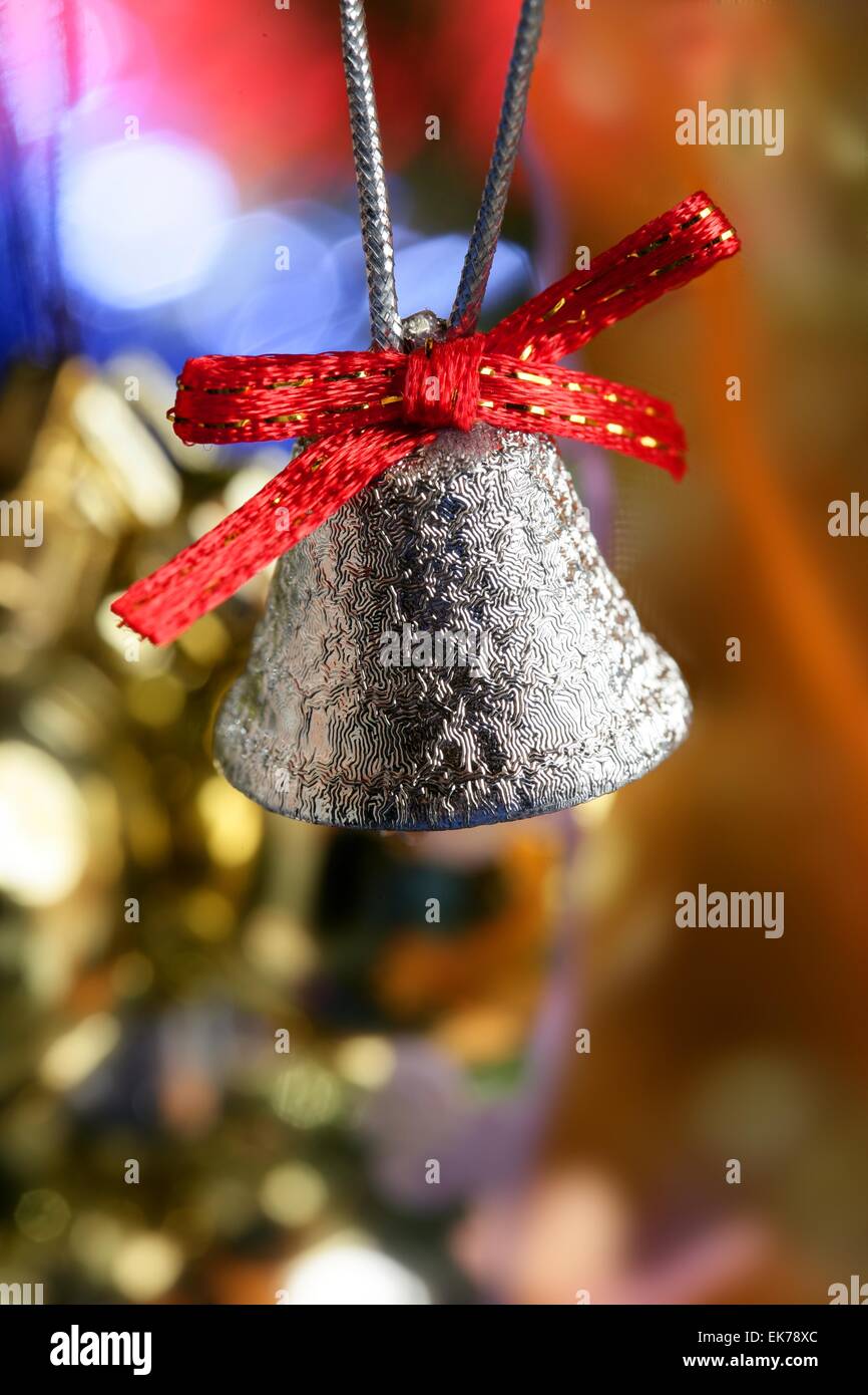 Silver bell in the christmas tree with red ribbon Stock Photo - Alamy