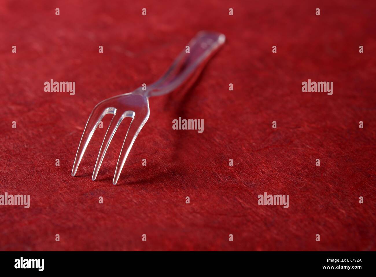 Transparent plastic fork on a textured vivid Stock Photo - Alamy