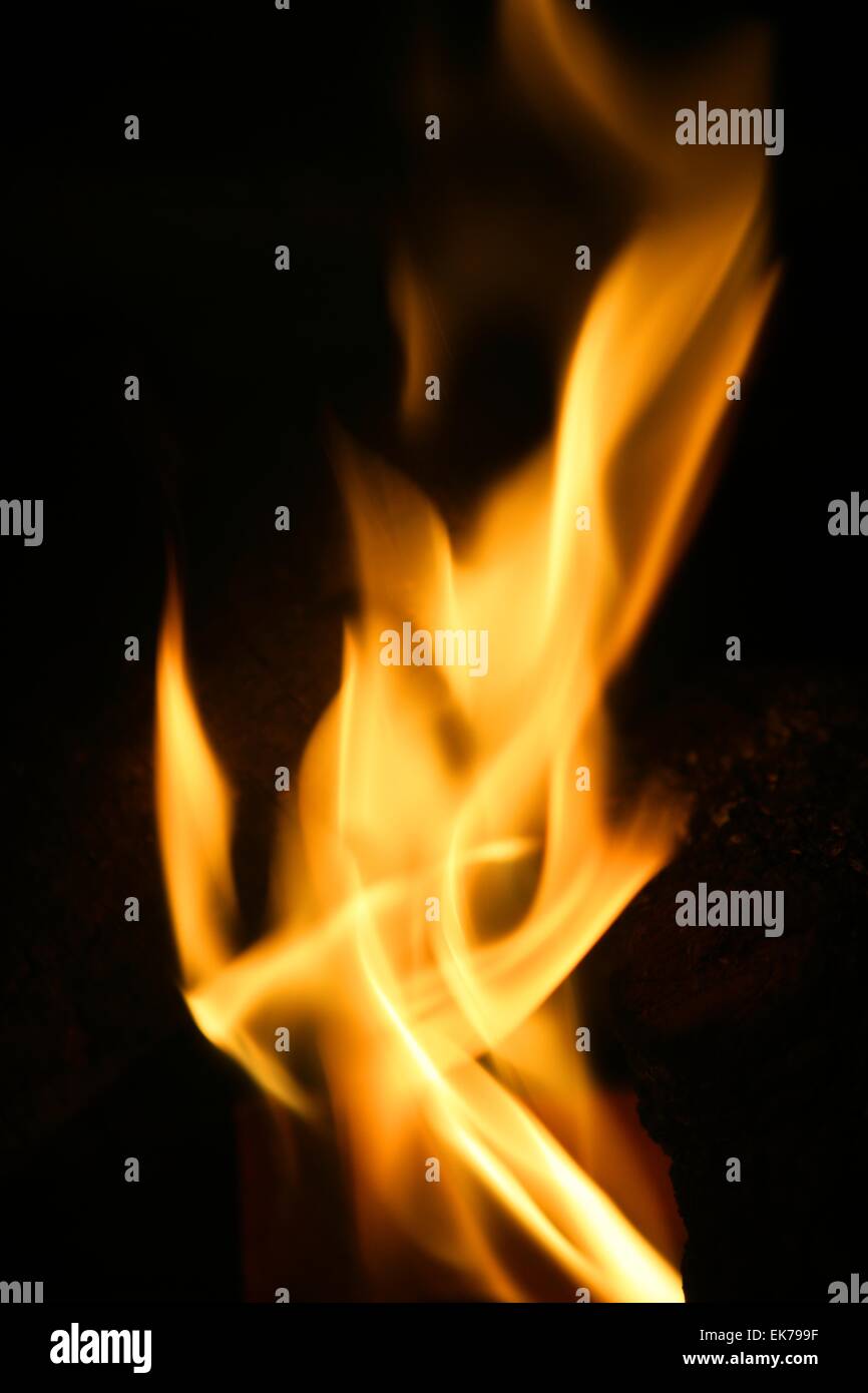 Orange fire over black background Stock Photo - Alamy