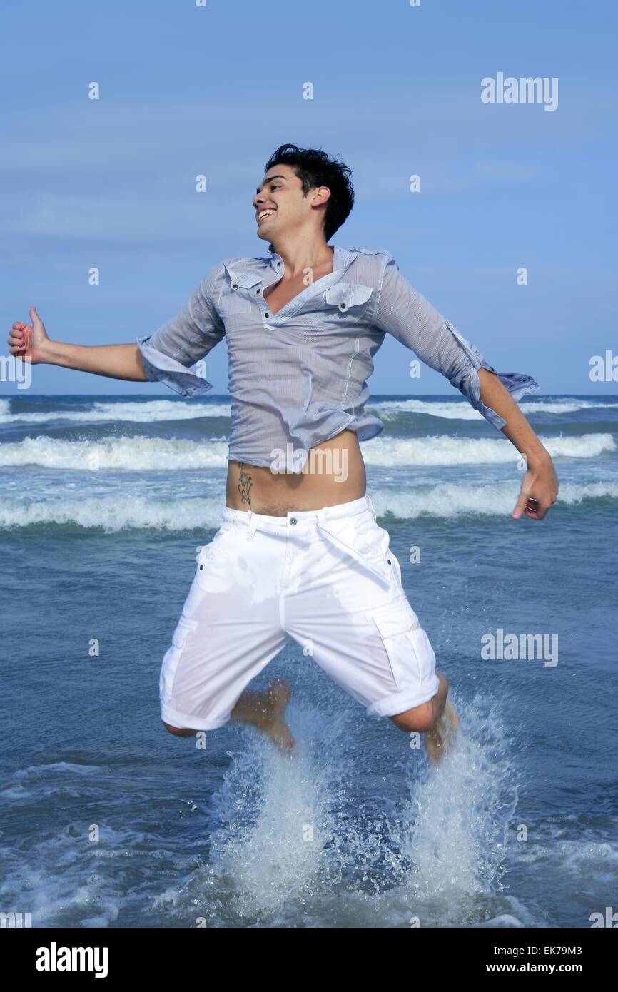 Handsome young man on the blue ocean beach Stock Photo - Alamy