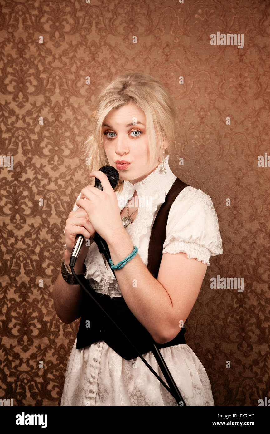 Pretty young singer or comedian with microphone Stock Photo - Alamy