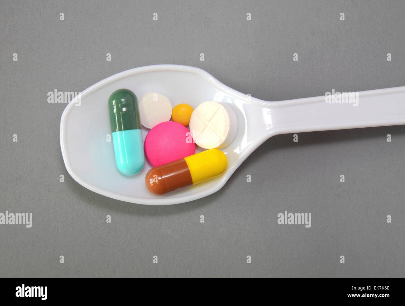 A spoonful of Pills and capsules Stock Photo - Alamy