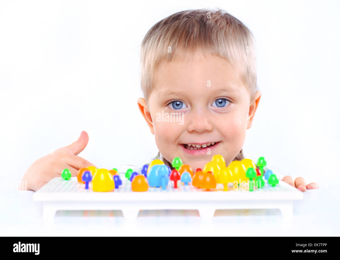 Little cute boy playing with multicolored mosaic Stock Photo - Alamy