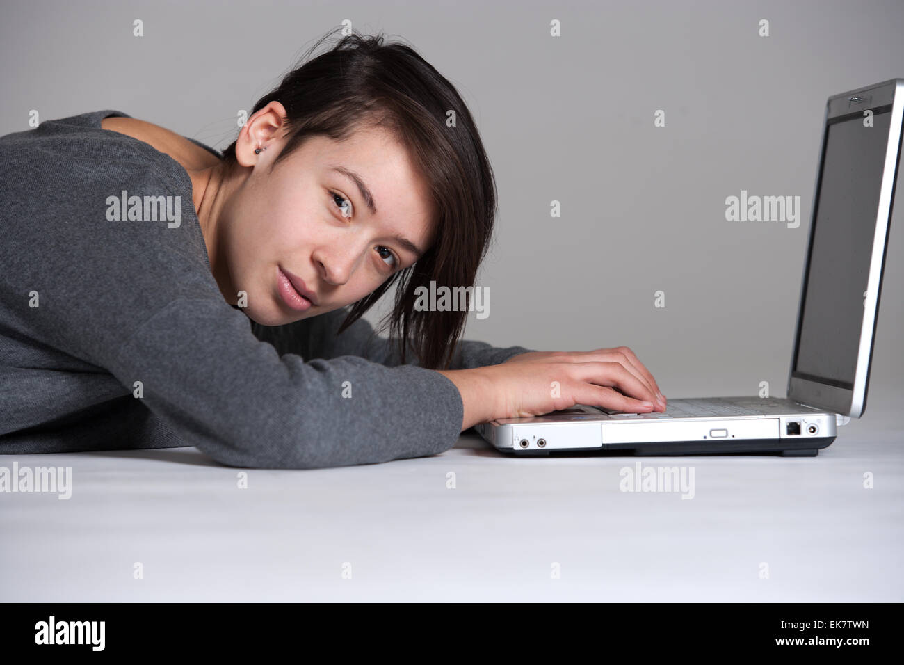 Young woman on floor with notebook Stock Photo - Alamy