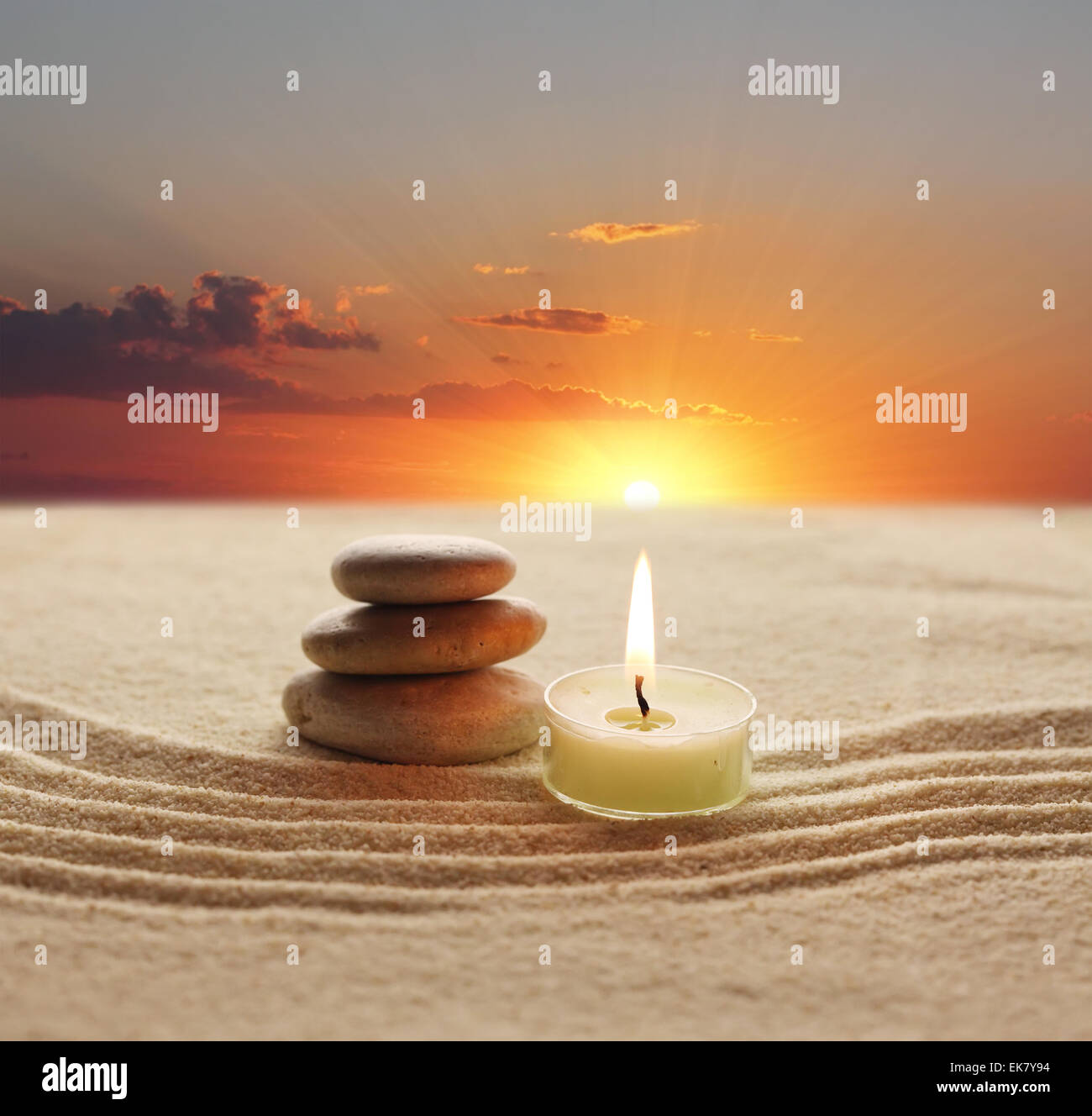 Stack of pebbles and light candle Stock Photo - Alamy
