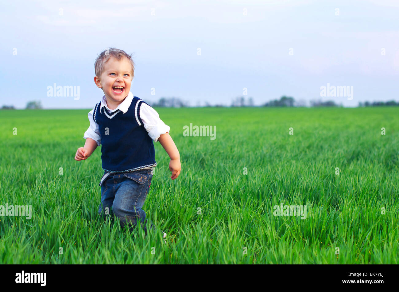 A beautiful little boy runing in the grass Stock Photo - Alamy