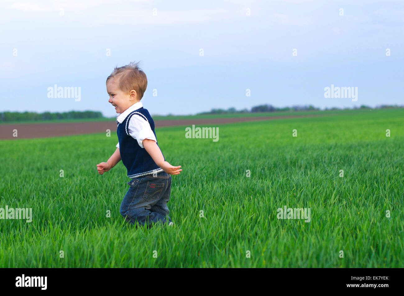 A beautiful little boy runing in the grass Stock Photo - Alamy