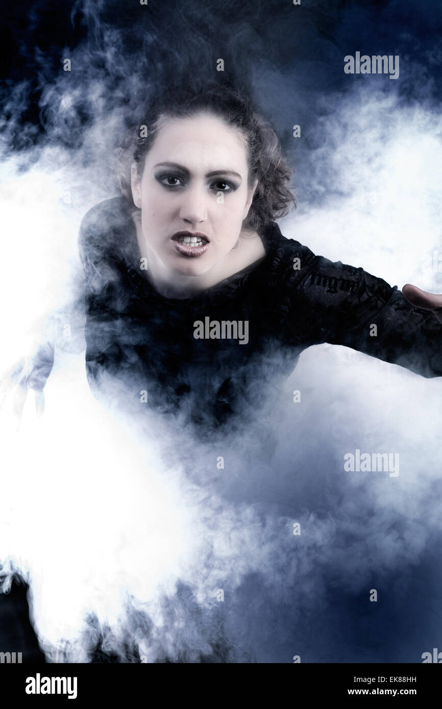 Woman with long curly hair crawling out of smoke Stock Photo - Alamy