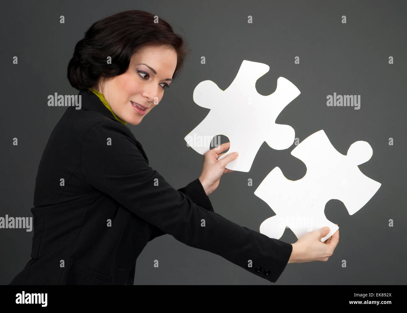 Woman Working With Two Large Jigsaw Puzzle Pieces Stock Photo - Alamy