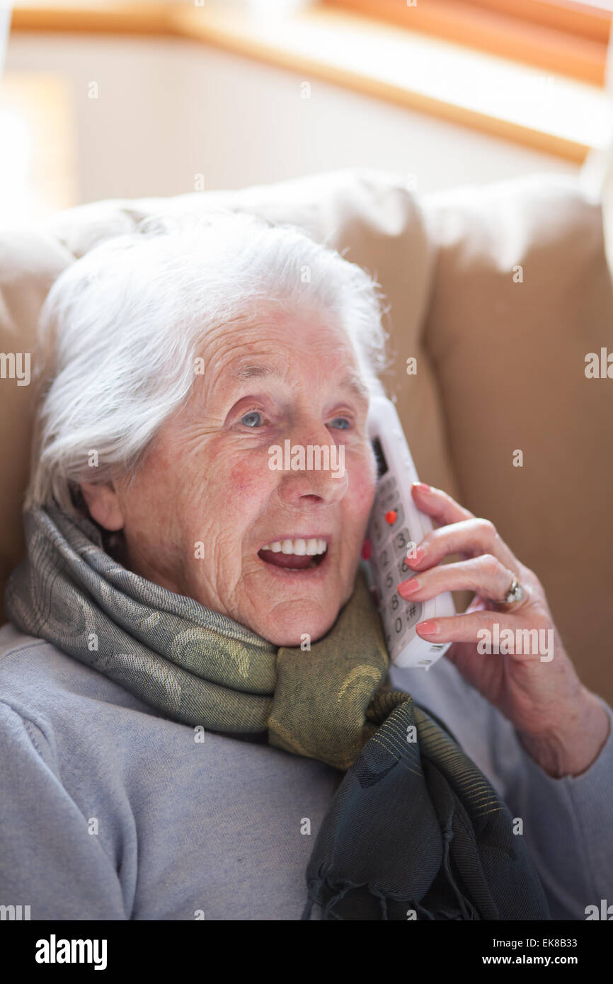 Old lady sitting in easy chair talking on the phone Stock Photo - Alamy