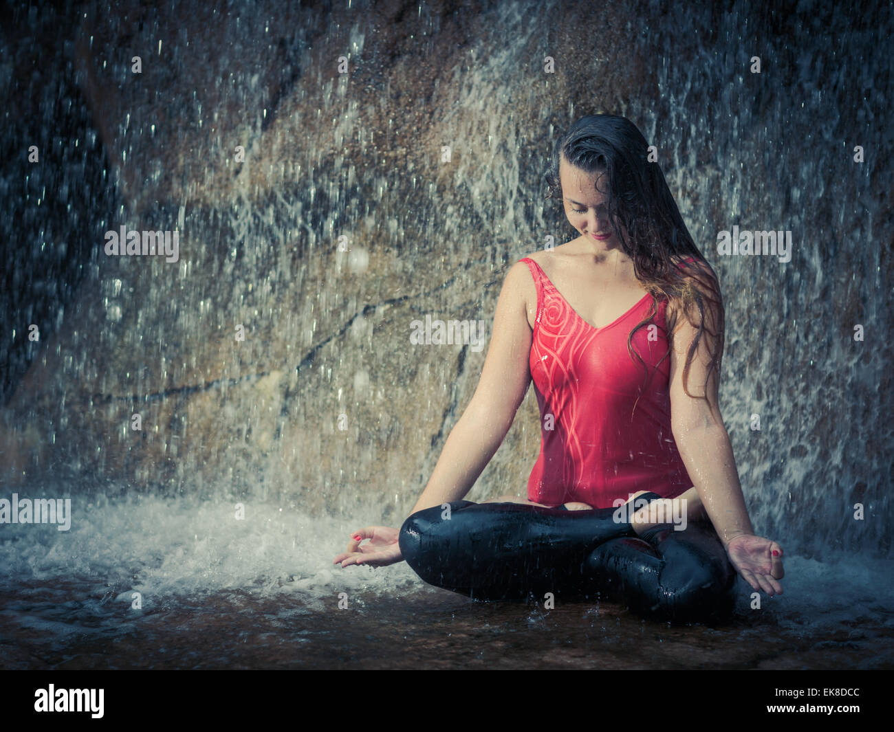 Woman practicing yoga near waterfall. Lotus Pose. Padmasana Stock Photo ...