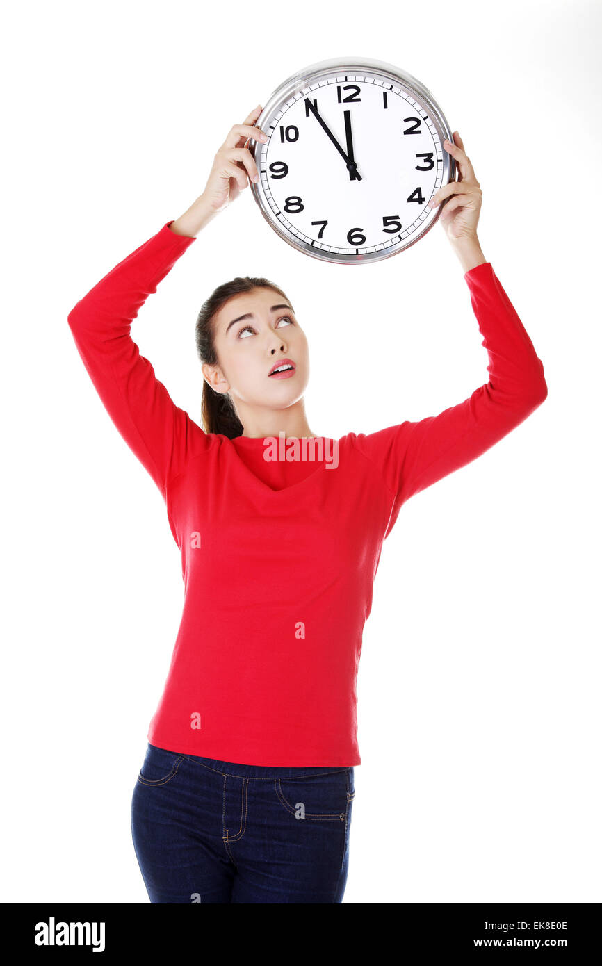 Shocked woman holding office clock Stock Photo - Alamy