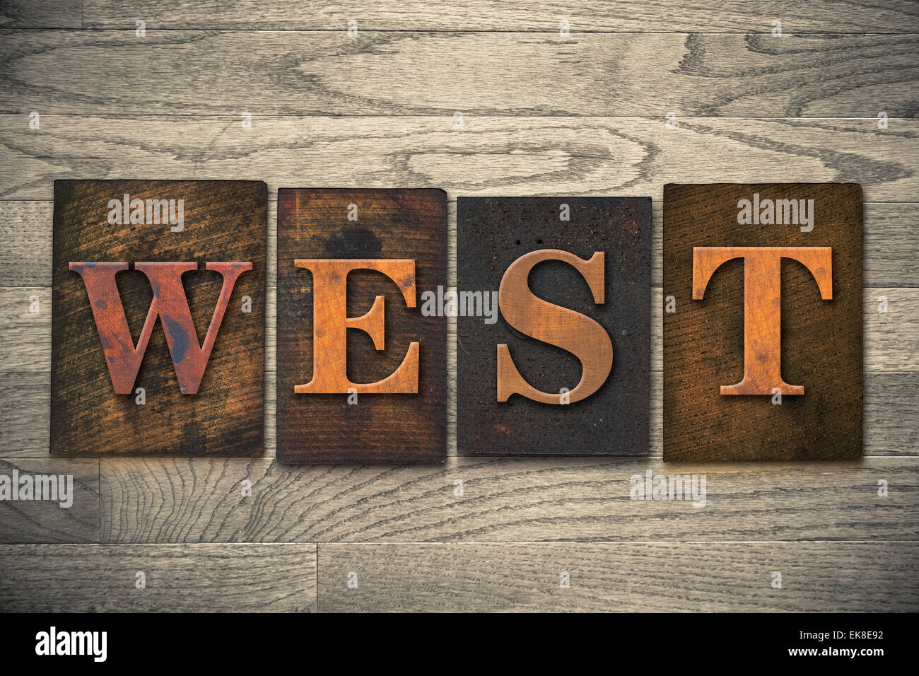 The word "WEST" theme written in vintage, ink stained, wooden ...