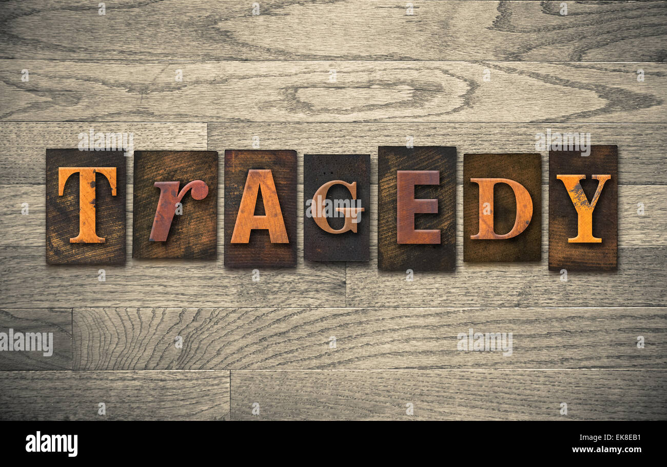 The word "TRAGEDY" theme written in vintage, ink stained, wooden ...