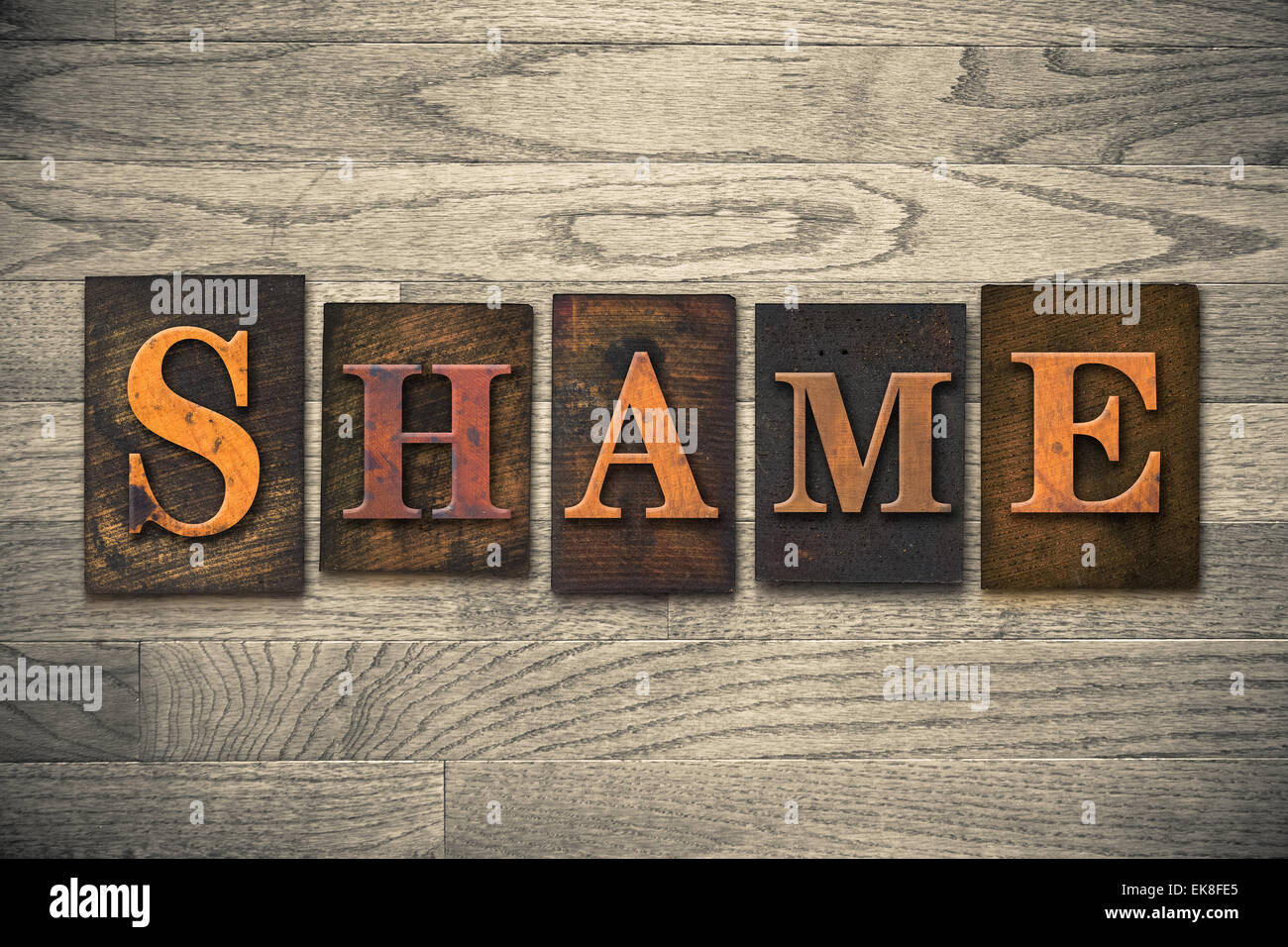 The word "SHAME" theme written in vintage, ink stained, wooden ...
