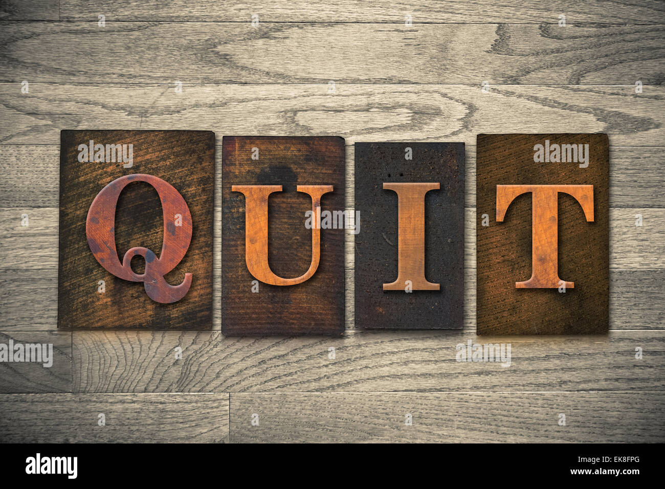 The word "QUIT" theme written in vintage, ink stained, wooden ...