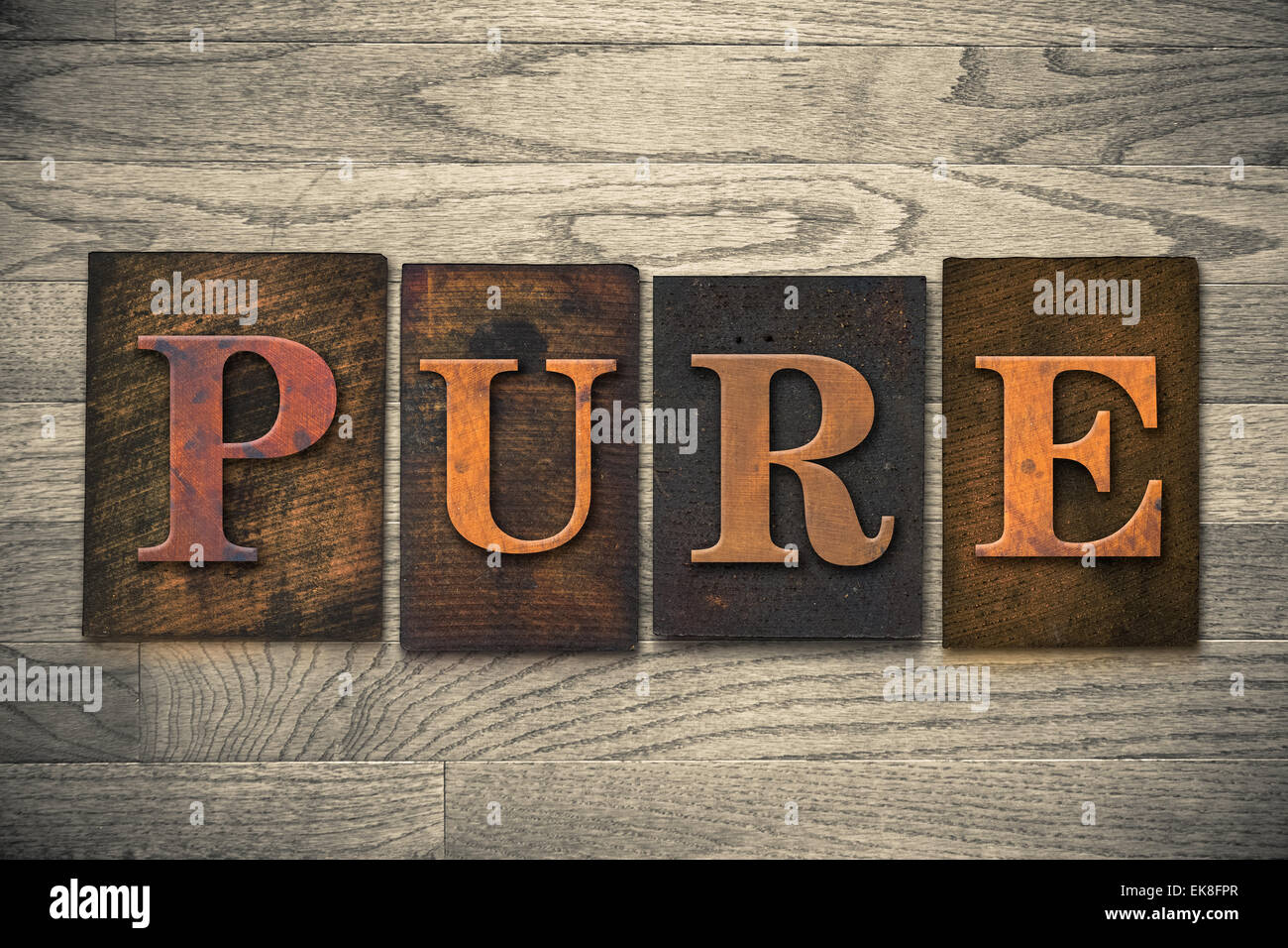 The word "PURE" theme written in vintage, ink stained, wooden ...