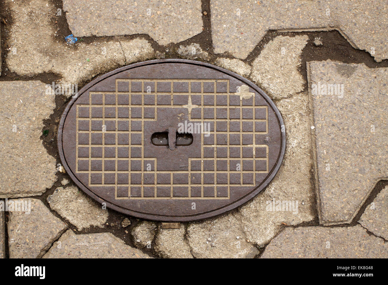 Manhole cover surrounded by pavement granite stones Stock Photo - Alamy