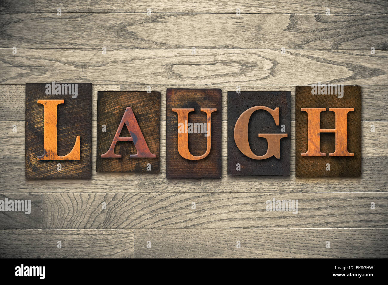 The word "LAUGH" theme written in vintage, ink stained, wooden ...
