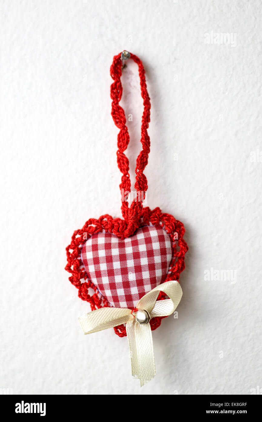 handmade knitted heart shape hanging on the white wall Stock Photo - Alamy