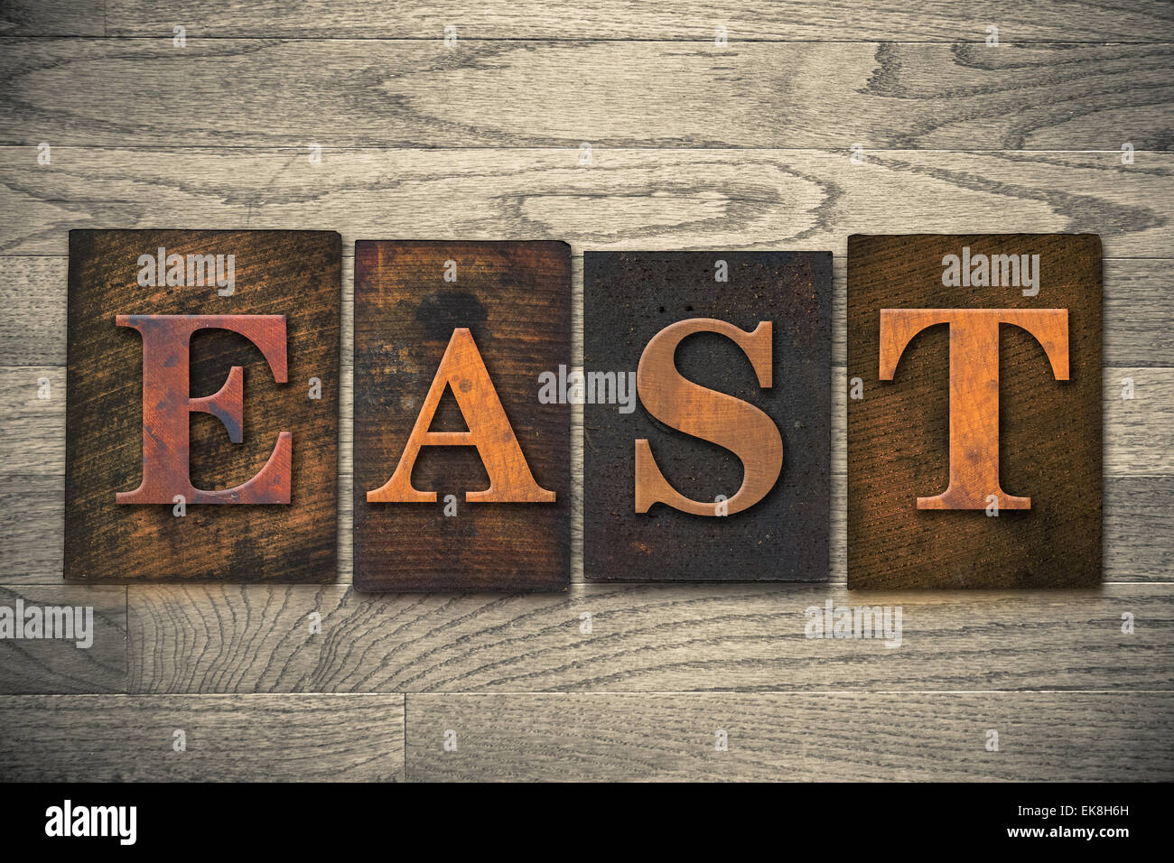 The word "EAST" theme written in vintage, ink stained, wooden ...