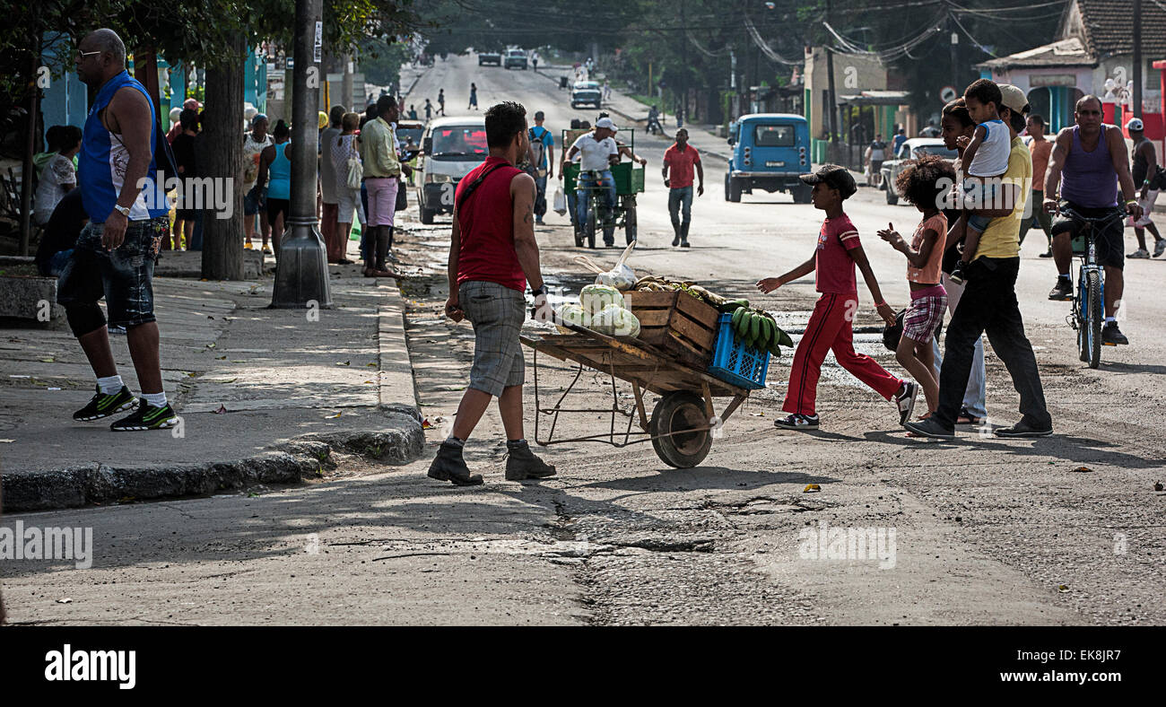 Man with fruit and vegetable market stall crossing a very busy road in ...