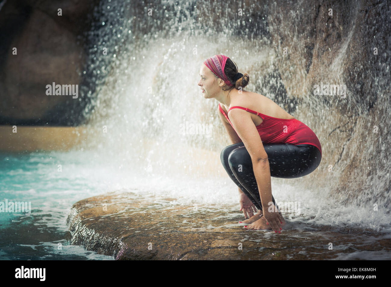 Woman practicing yoga near waterfall. Awkward Pose. Utkatasana Stock ...