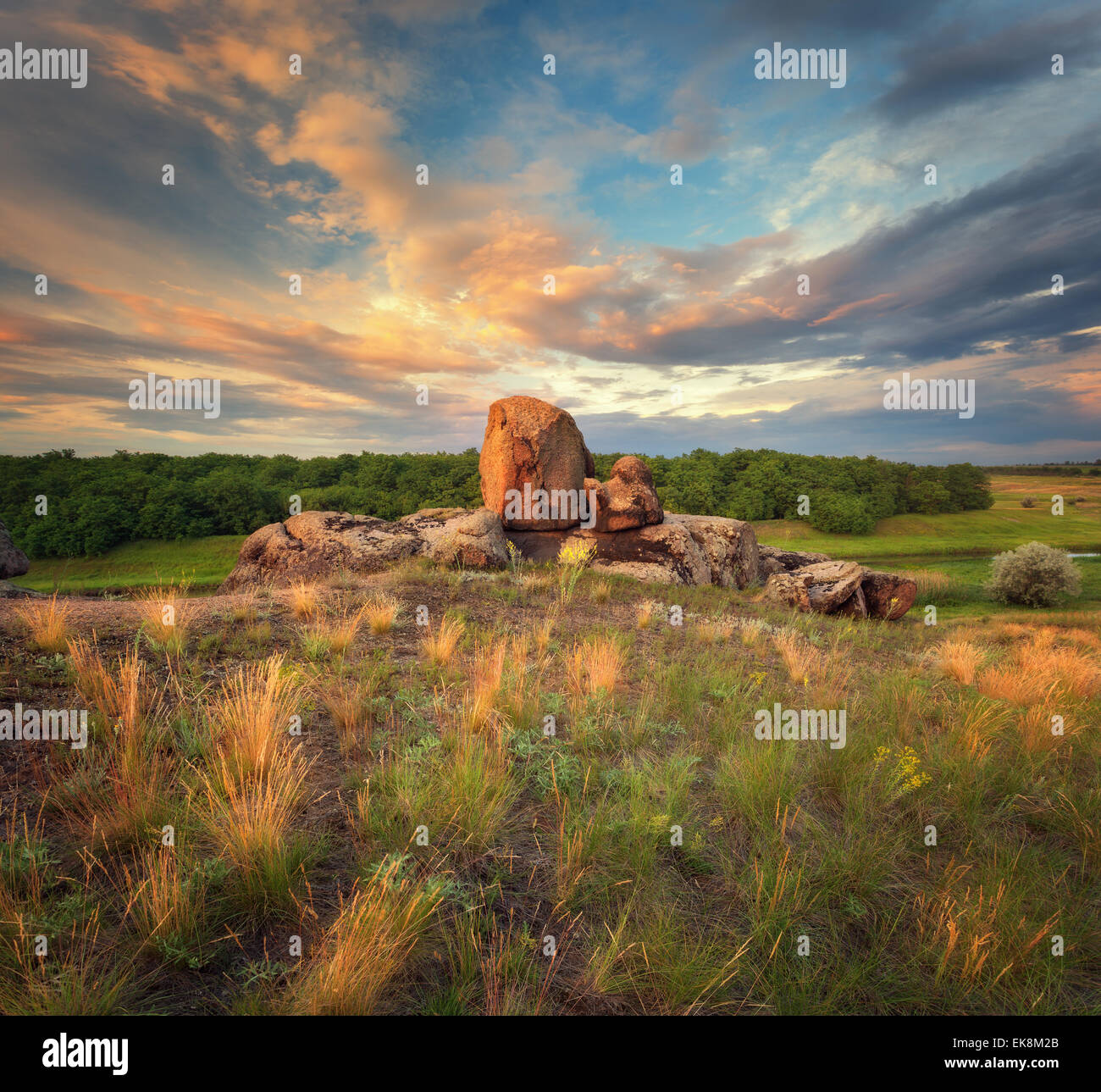 Beautiful summer sunset with blue sky, orange clouds, rocks, yellow ...