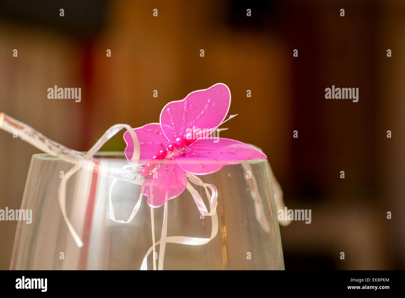 Pink butterfly hanging from a crystal glass Stock Photo - Alamy