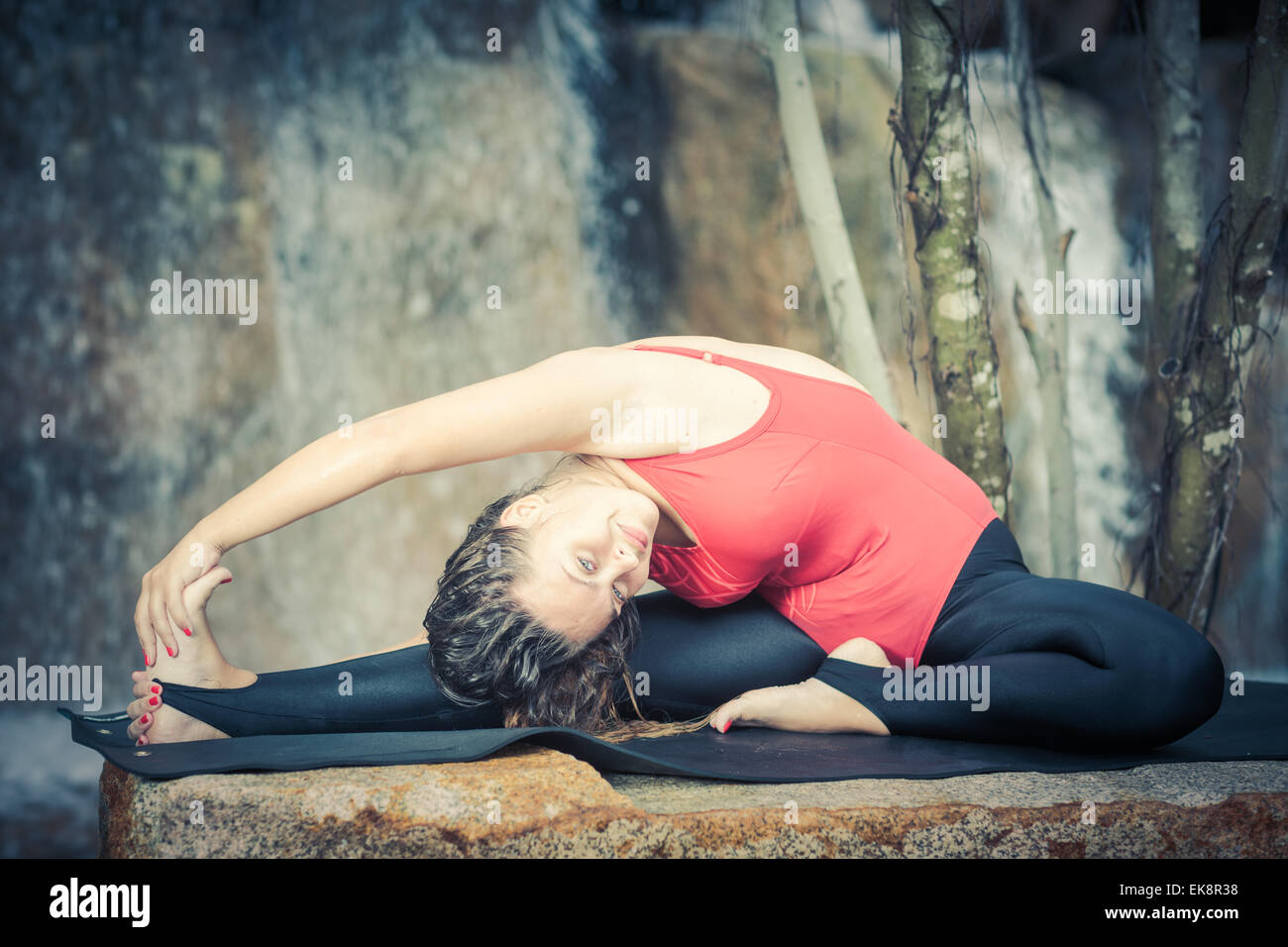 Young woman is practicing yoga near waterfall Stock Photo - Alamy