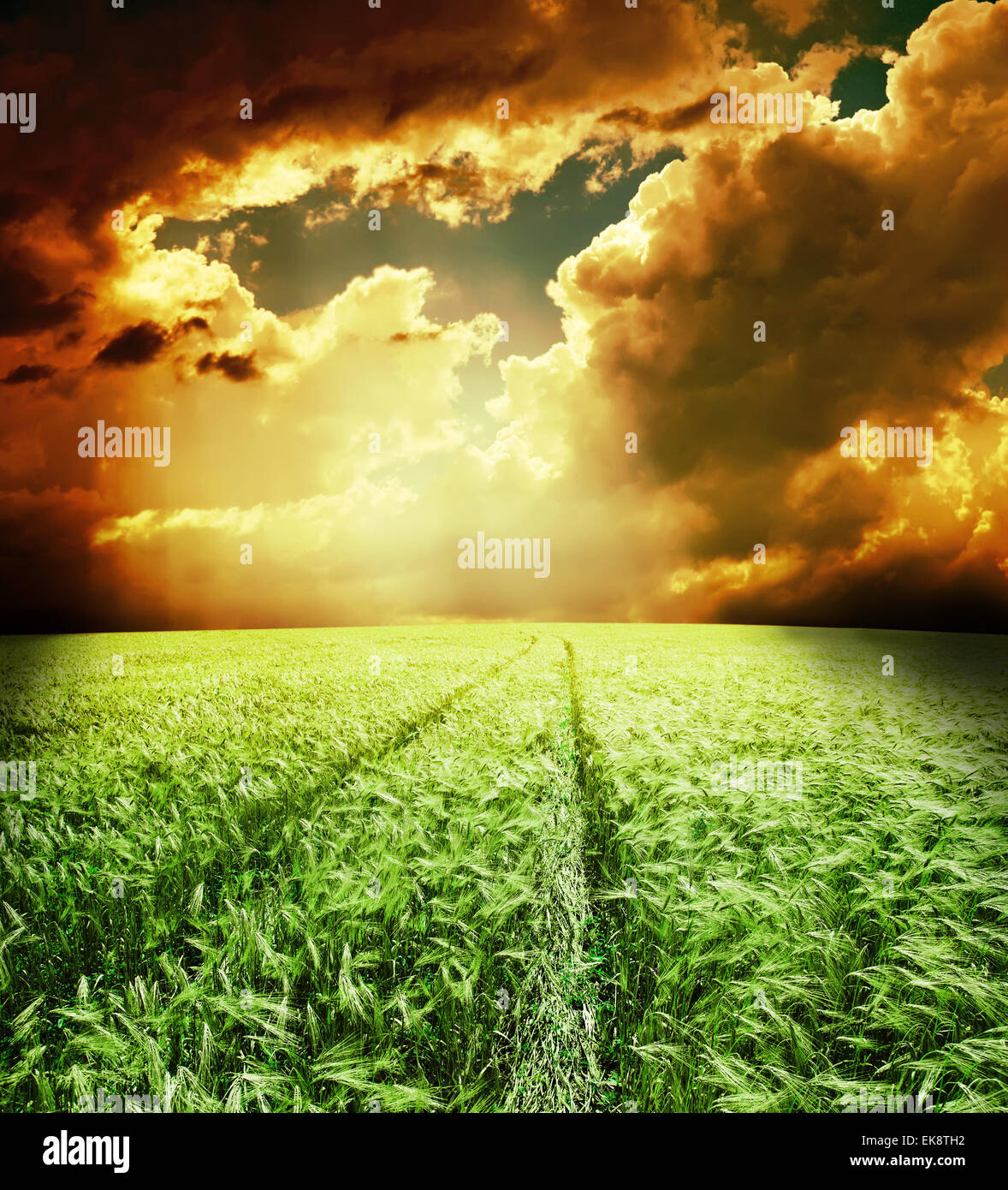 green field with road under dramatic sky Stock Photo - Alamy