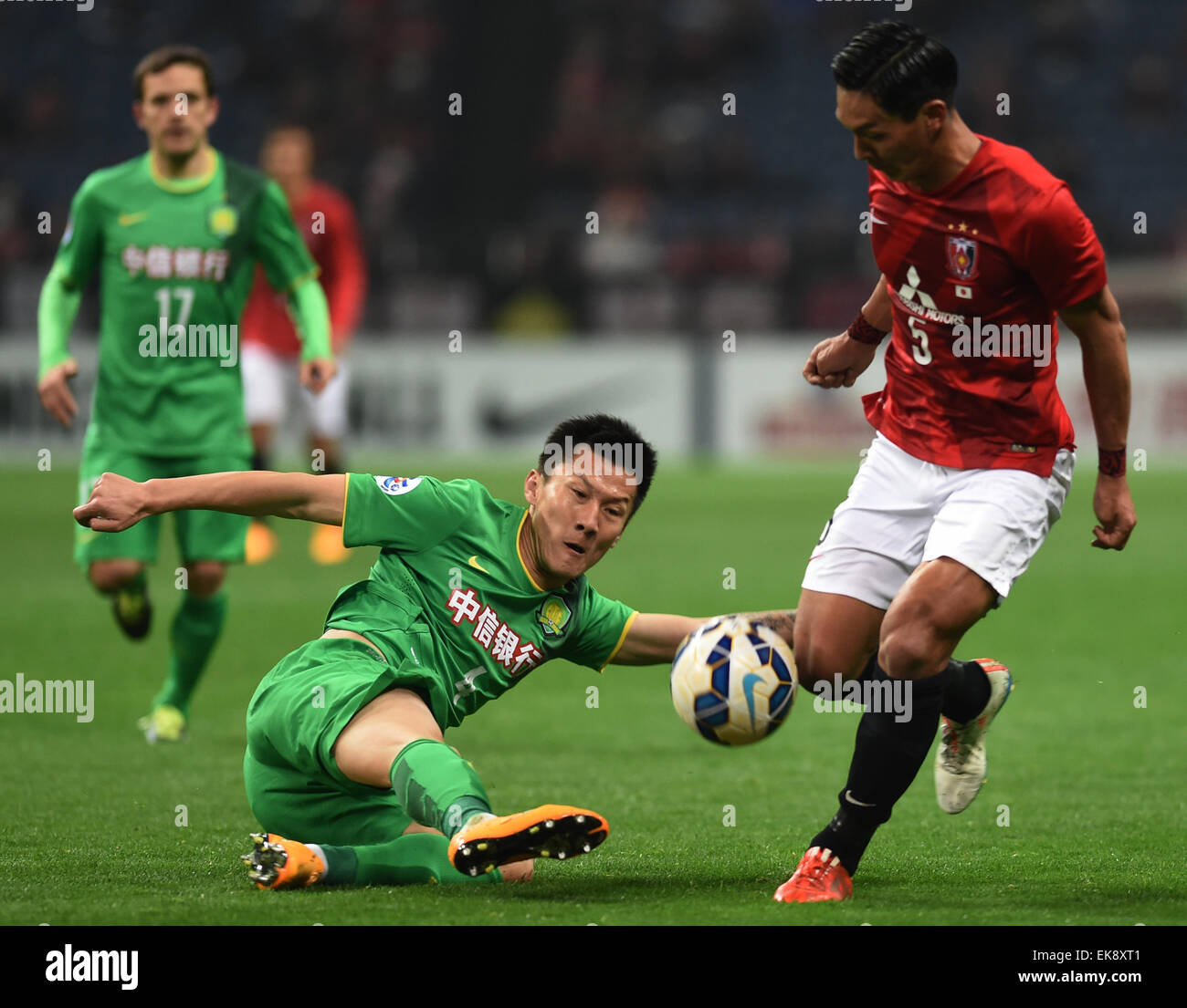 Saitama, Japan. 8th Apr, 2015. Zhou Ting (bottom) of China's Beijing Guoan vies with Tomoaki ...