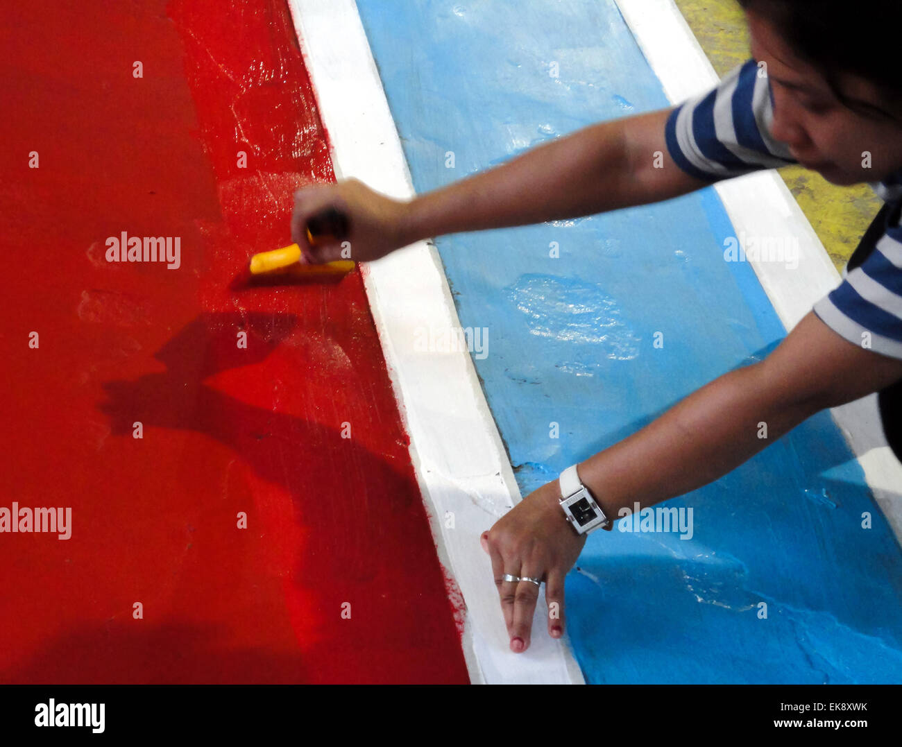 Quezon City, Philippines. 08th Apr, 2015. A Filipino repaints the faded ...