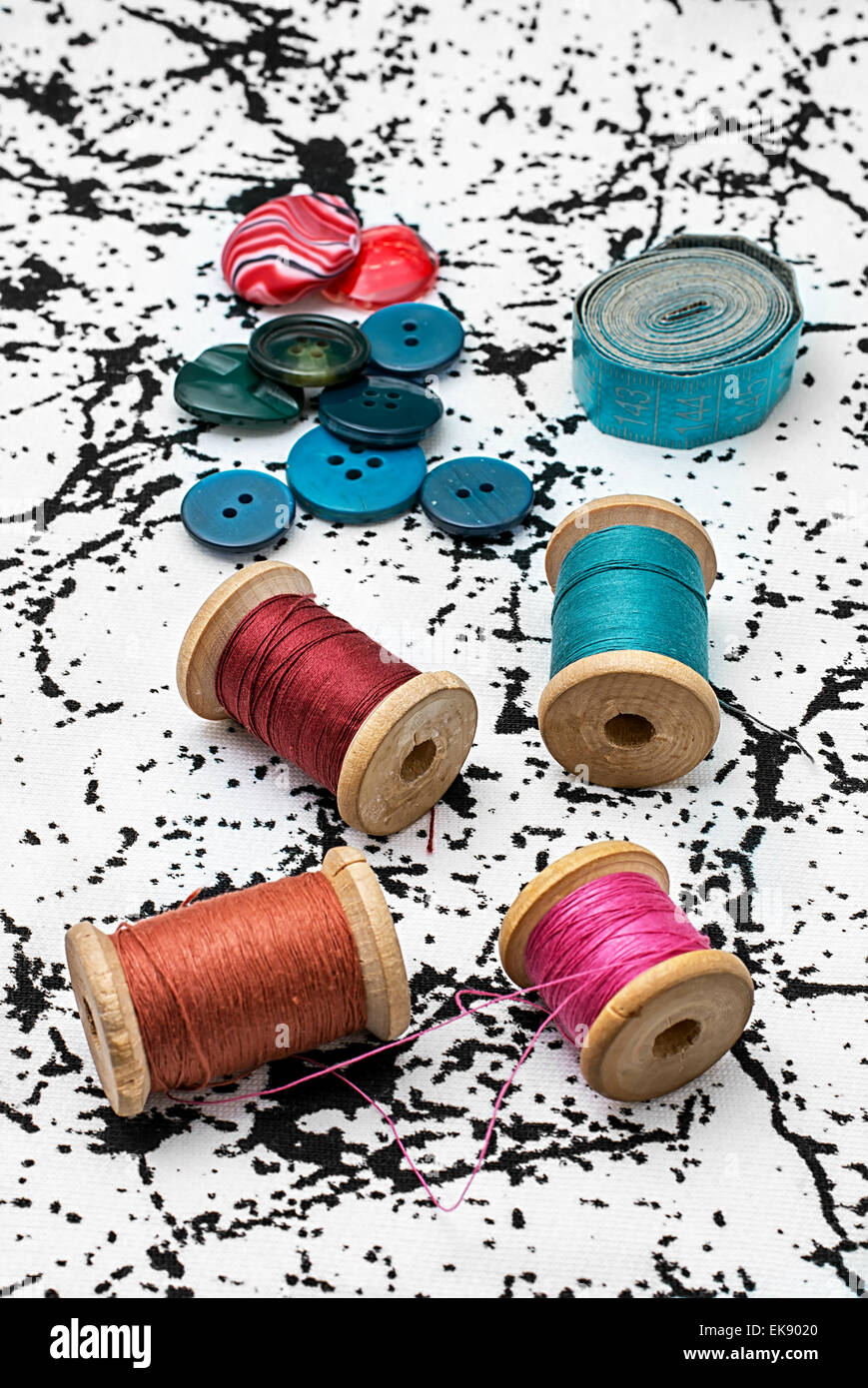 thread and buttons against the background of their white textile with ...