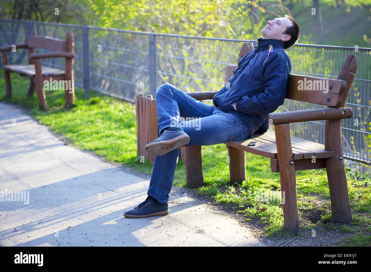 a man sitting on a park bench Stock Photo - Alamy