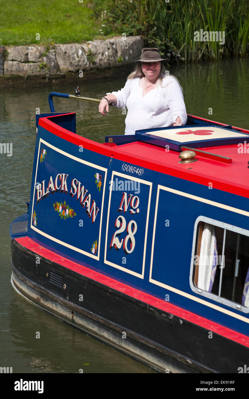 Woman steering Black Swan narrow boat narrowboat on the Kennet and Avon ...
