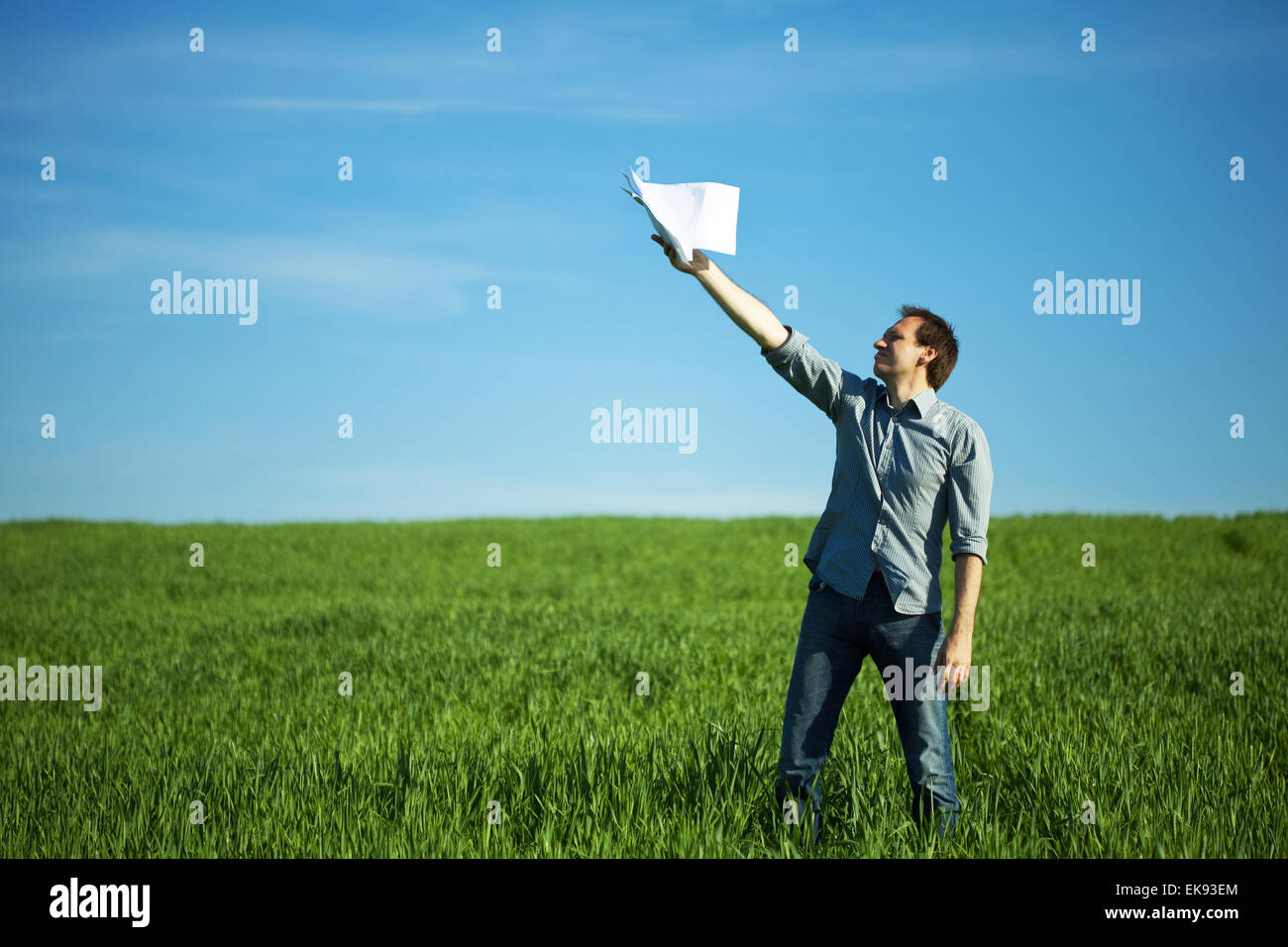 man throws the paper in the field Stock Photo - Alamy