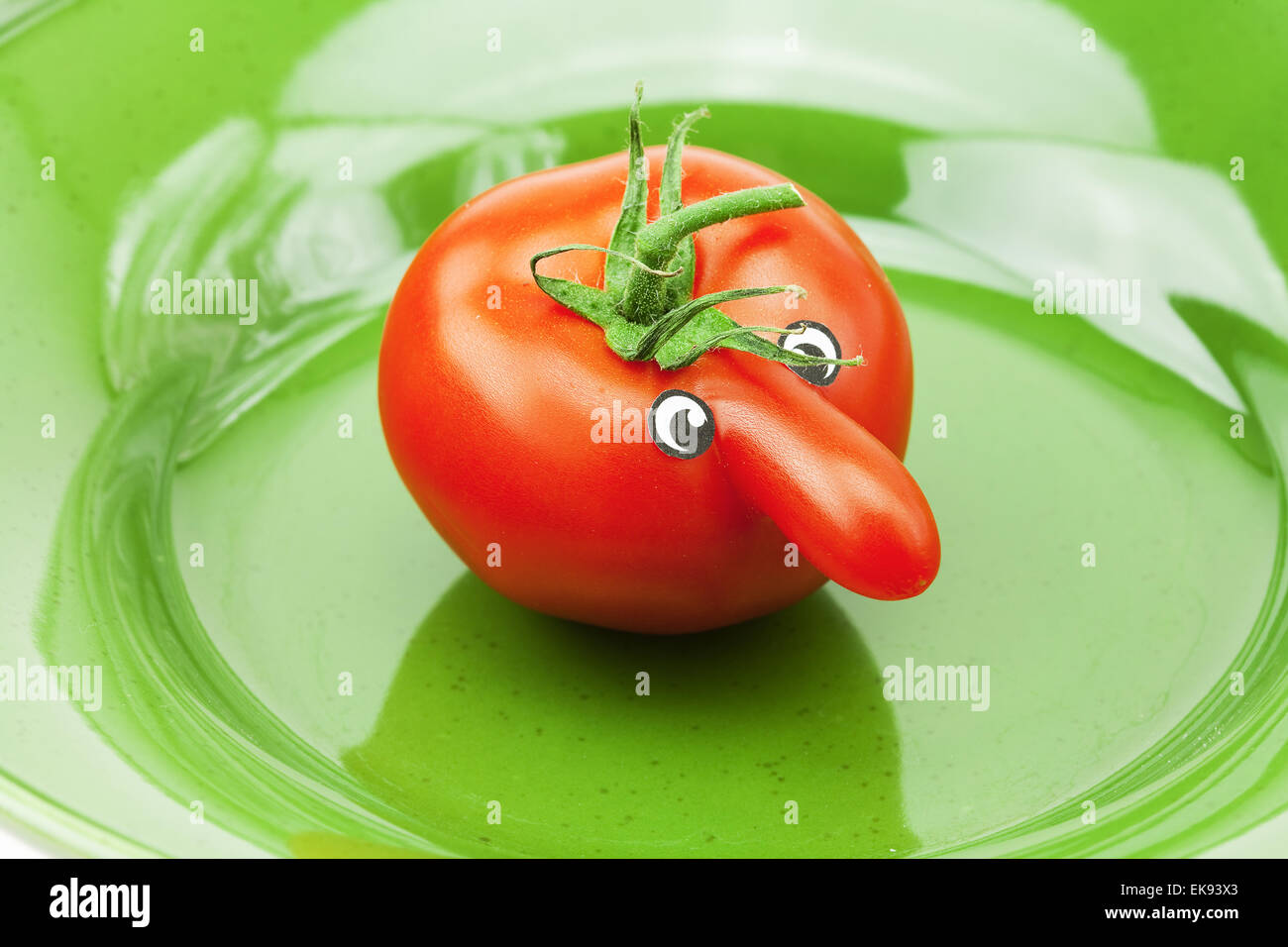 tomato with a nose on a green plate Stock Photo - Alamy