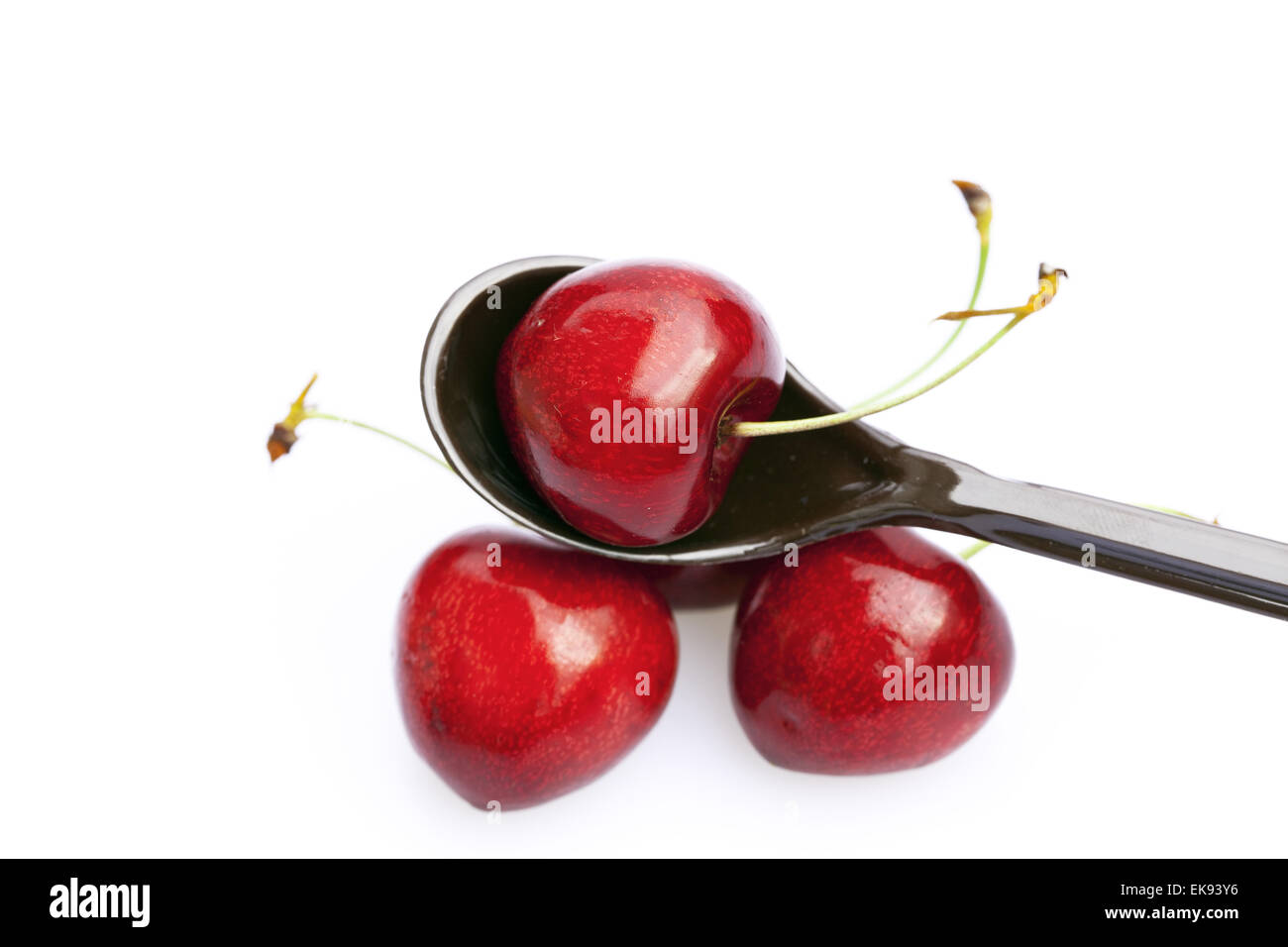 cherry in a spoon isolated on white Stock Photo - Alamy