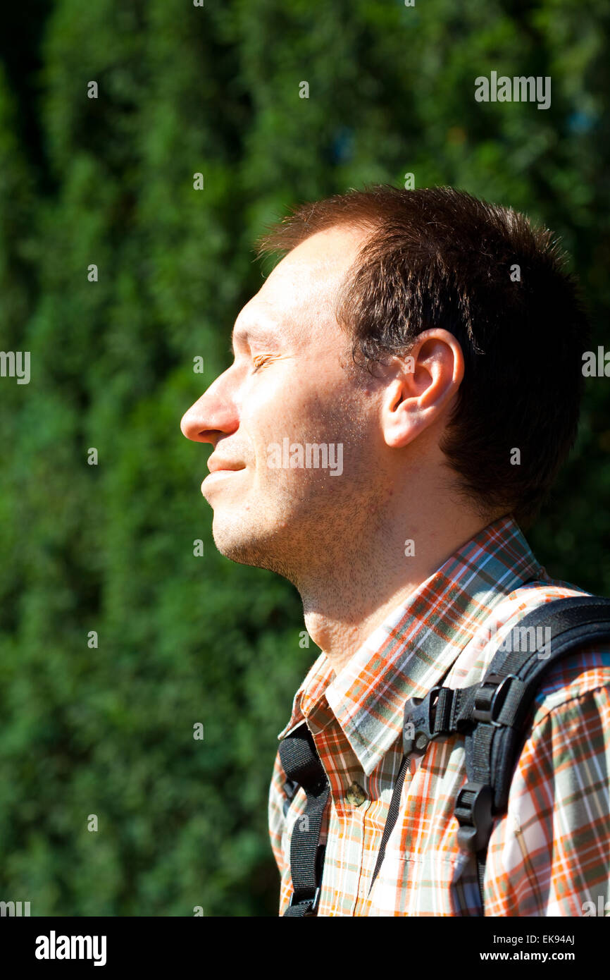 Man on a background of green foliage Stock Photo - Alamy
