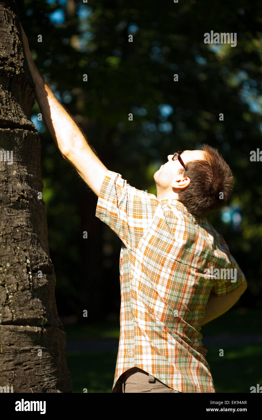 Man on a background of green foliage Stock Photo - Alamy