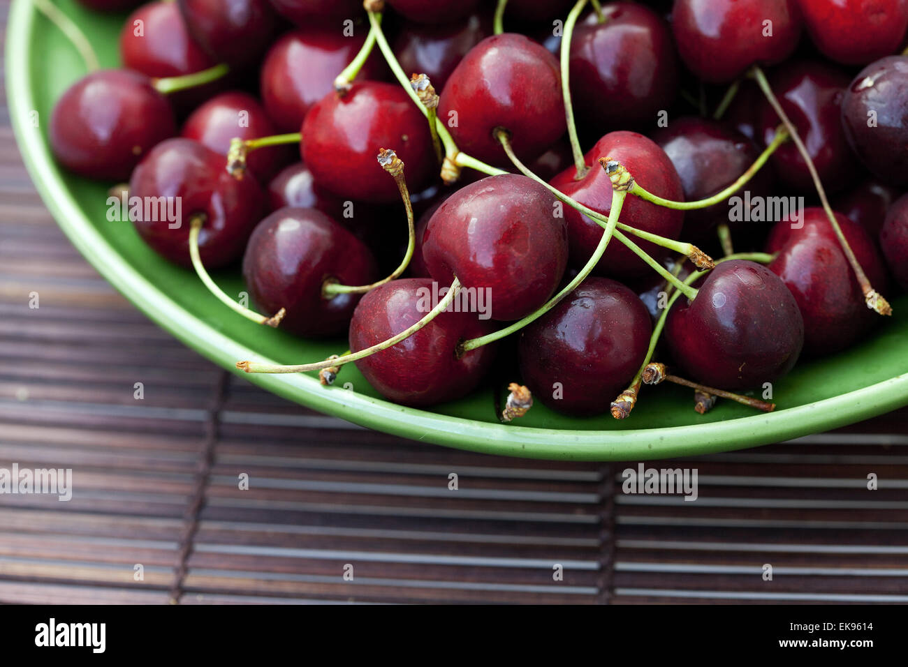 cherry in plate on a bamboo mat Stock Photo - Alamy