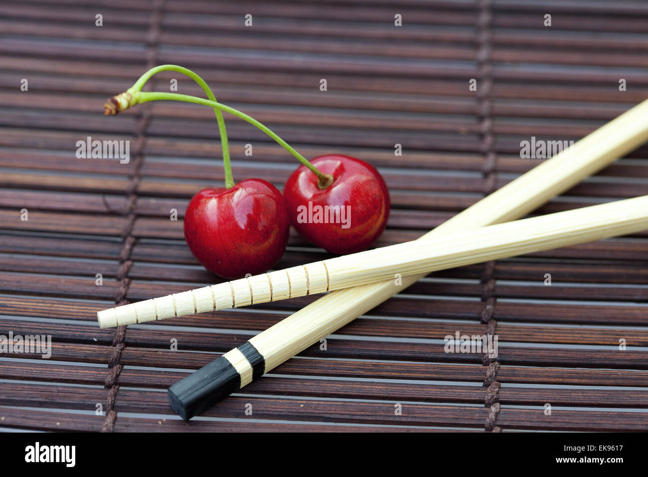 cherry and chopsticks on bamboo mat Stock Photo - Alamy